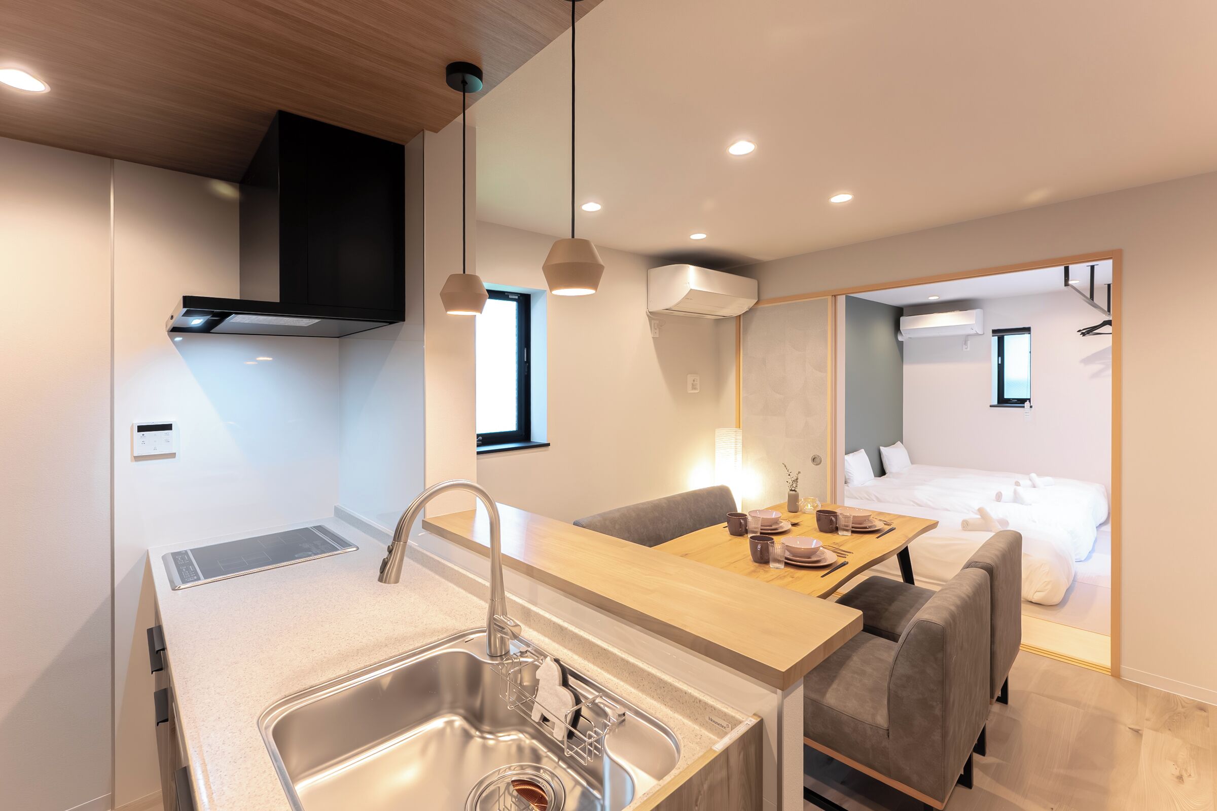 Uma cozinha moderna com forno embutido, pia e área de jantar com mesa e cadeiras.