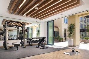 Uma academia moderna com equipamentos de musculação, um tapete de yoga e um kettlebell.