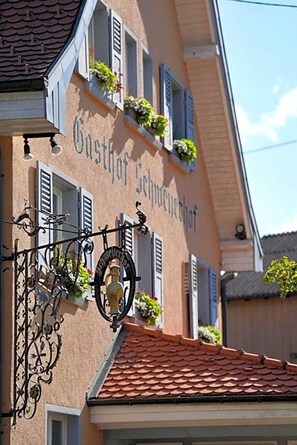 Um edifício com uma placa indicando 'Gasthof Schneyerhof' e um estilo arquitetônico tradicional europeu.