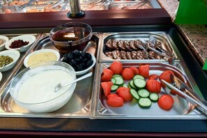 Buffet com diversos itens, incluindo patês, frutas e legumes.