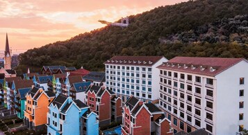 Uma cidade com casas coloridas e um edifício branco grande com várias janelas.