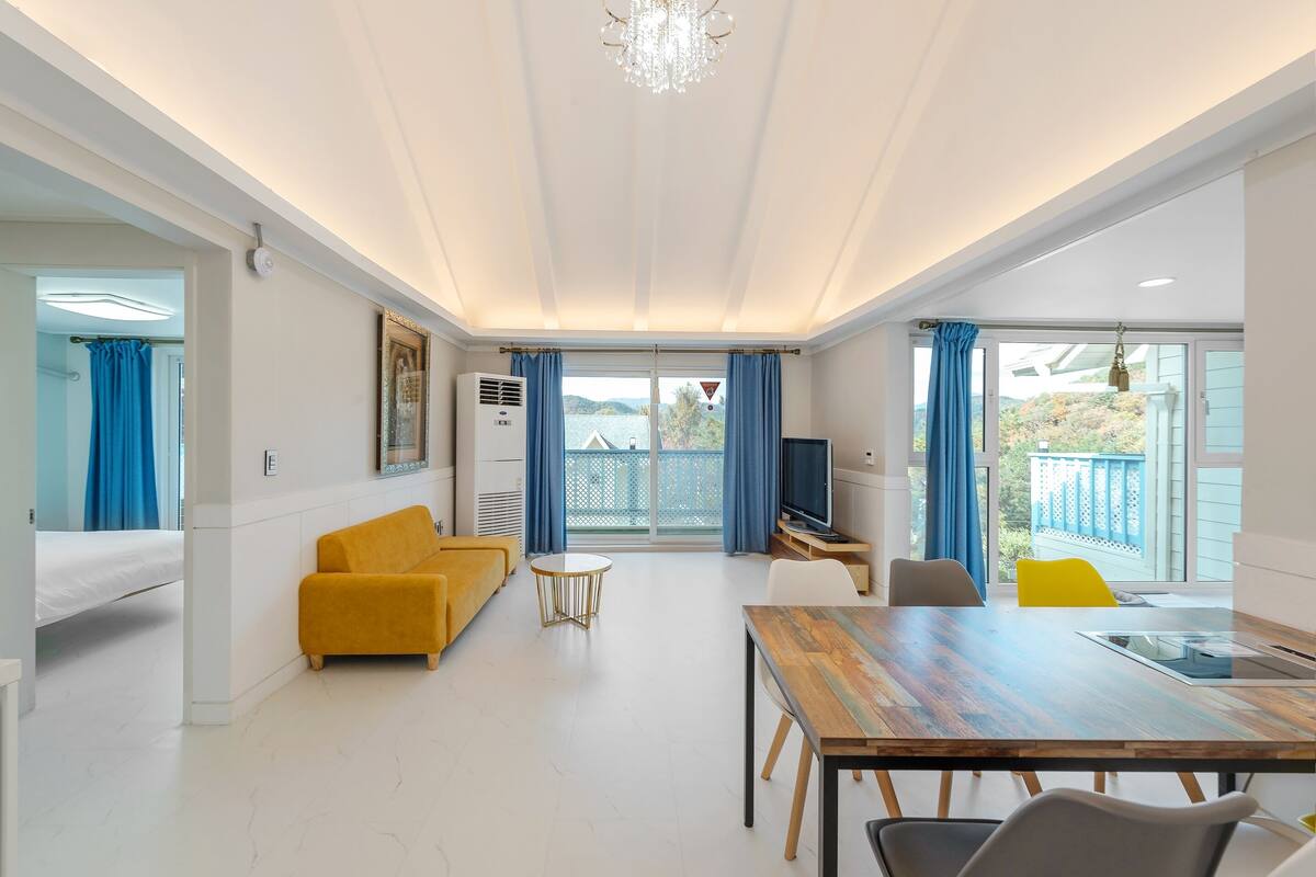 Uma sala de estar moderna com sofá, mesa de jantar e televisão.