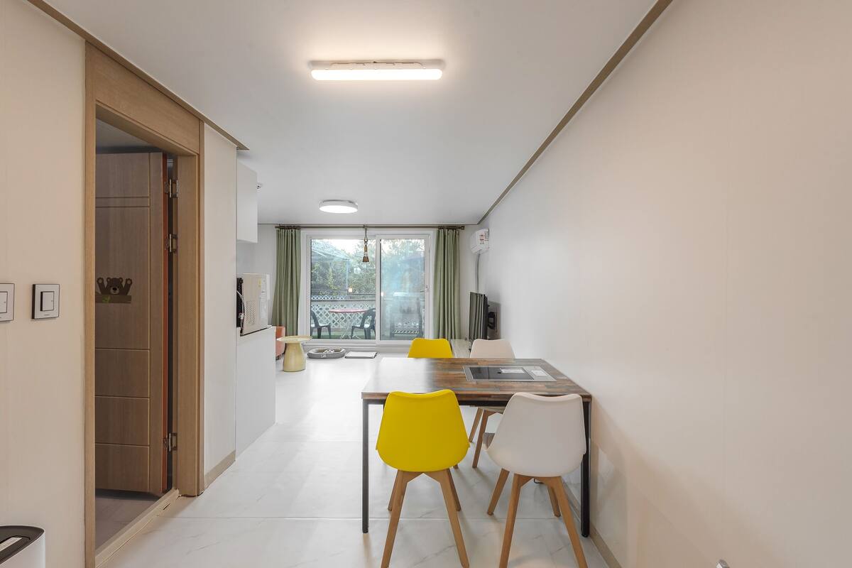 Cozinha moderna com área de jantar, porta deslizante e vista pela janela.