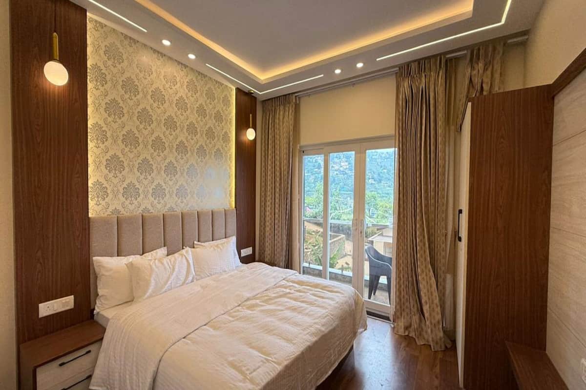 Quarto com cama grande, cabeceira de madeira, parede estampada e porta de vidro deslizante para o exterior.