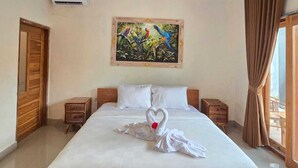 Quarto de hotel com cama, um quadro, ar condicionado, móveis de madeira e vista pelas cortinas.