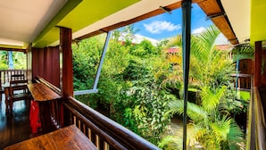 Um deck de madeira com vista para vegetação exuberante e um céu claro.