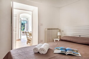 Quarto de hotel com cama, um livro e vista para o exterior.