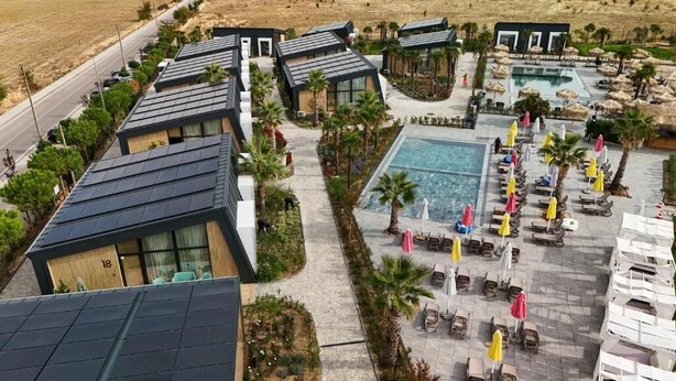 Um resort com vários edifícios, piscina e áreas de estar ao ar livre.