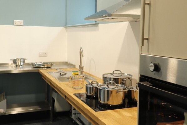 Uma cozinha moderna com eletrodomésticos de aço inoxidável, bancada de madeira e forno embutido.
