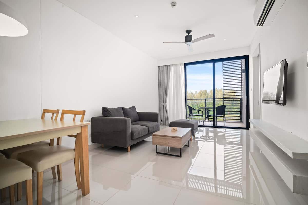 Uma sala de estar moderna com mesa de jantar, sofá e mesa de centro.