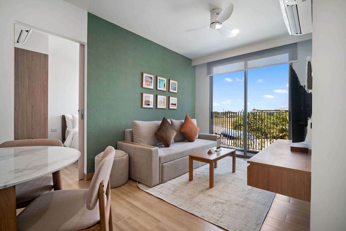 Uma sala de estar moderna com sofá, mesa de centro e área de jantar.