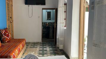 Quarto com uma cama, uma TV e vista para o exterior.