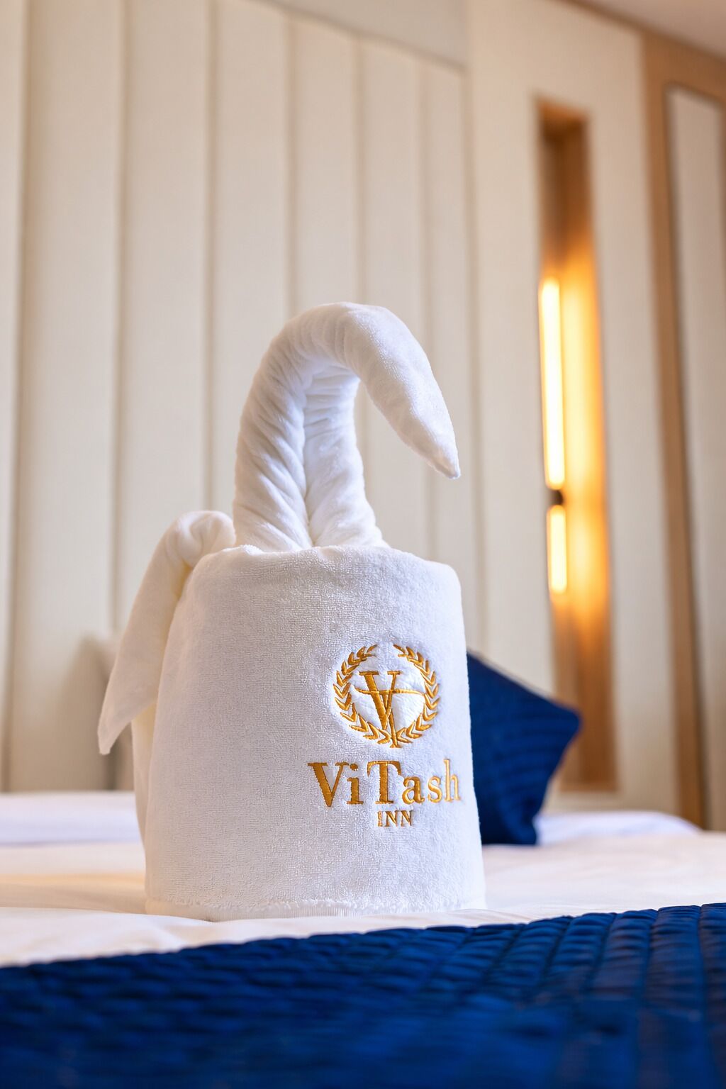 Uma toalha com logotipo e texto sobre uma cama.