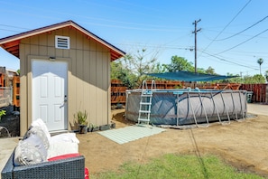 Um pequeno abrigo com porta, piscina coberta e escada.