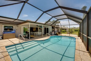 Piscina coberta com área de varanda, ventilador de teto e vista para o quintal.