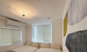 Quarto moderno com cama, ar condicionado e janela.