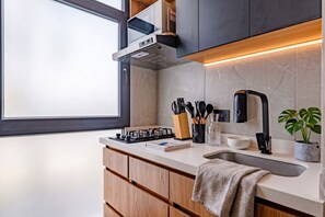 Cozinha moderna com fogão embutido, pia e janela que proporciona iluminação natural.