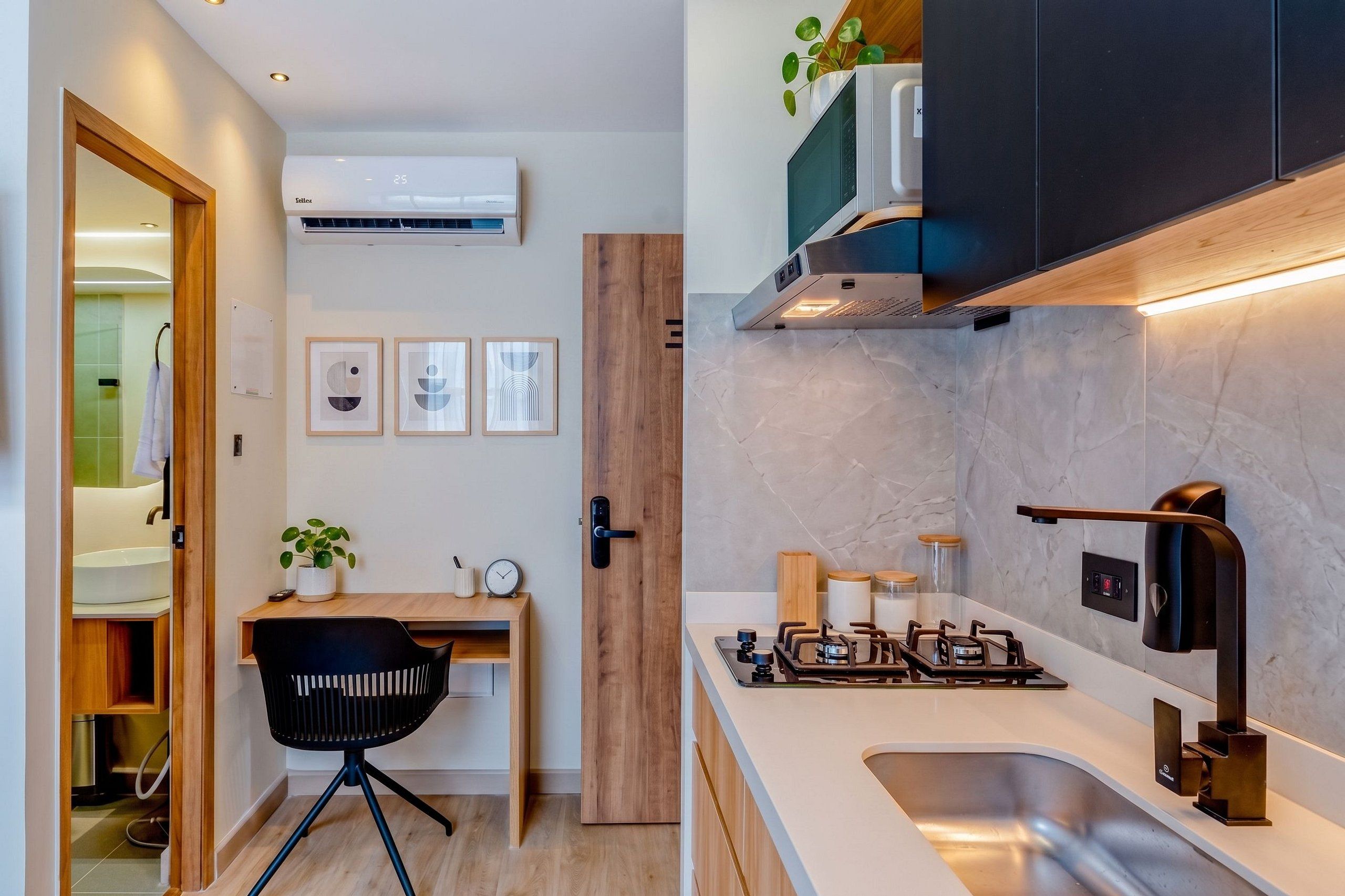 Cozinha moderna com fogão embutido, pia e área de jantar com uma cadeira e uma mesa pequena.