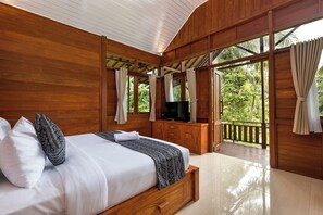 Quarto de madeira com cama, televisão e varanda com cortinas.