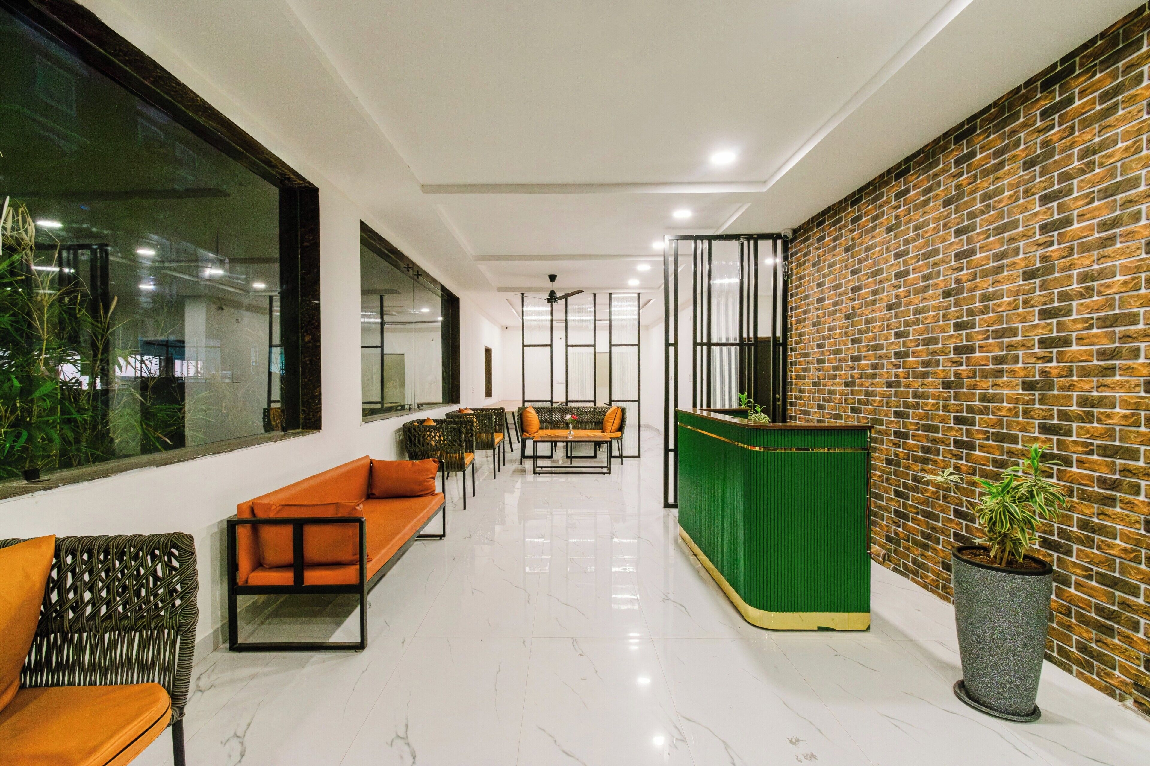 Um hall moderno com balcão de recepção, área de estar e parede de tijolos.