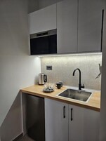 Quarto triplo superior, sacada, vista para a cidade | Cozinha americana privada | Máquina de café expresso, frigobar, micro-ondas, chaleira elétrica