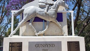 Estátua de um homem a cavalo com uma placa que diz 'Gunsynd The Goondiwindi Grey'.