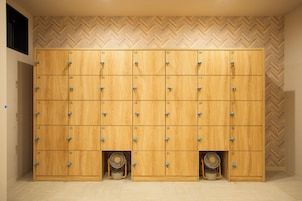 Fileira de armários de madeira com compartimentos numerados, alguns com ventiladores.