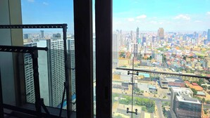 Um edifício alto com vista para o horizonte urbano através de amplas janelas.