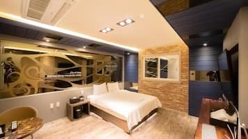 Quarto de hotel moderno com cama, escrivaninha, cadeira, mesa pequena e janela.