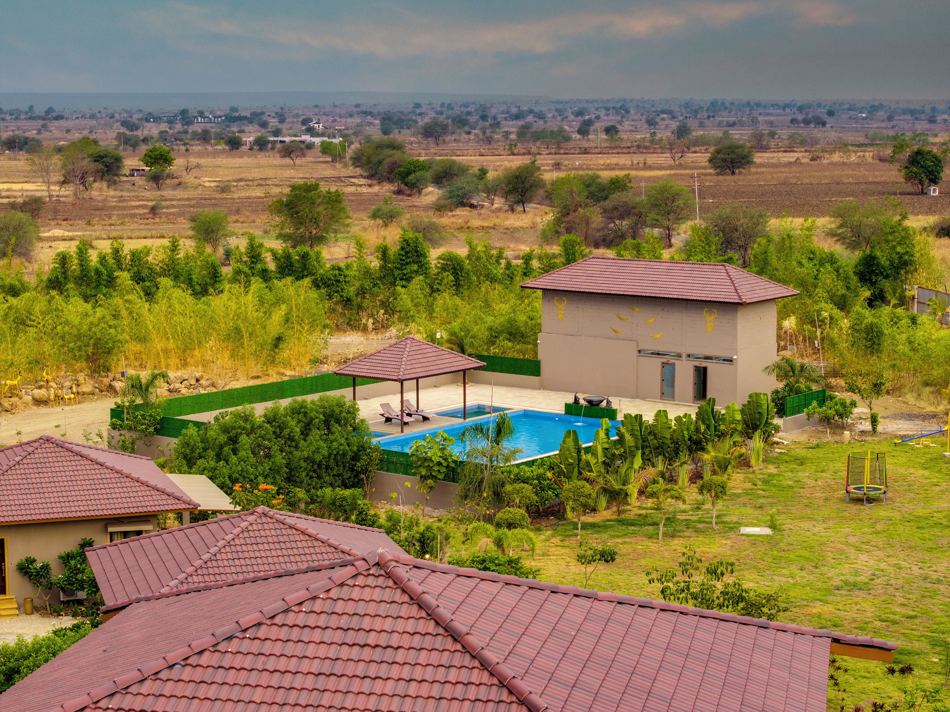 Um imóvel residencial com piscina, gazebo e vista para a paisagem ao redor.