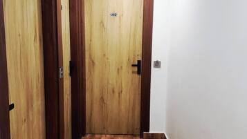 Corredor com portas de madeira, cada uma delas identificada com um número.