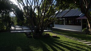 Um jardim ajardinado com um caminho que leva a um edifício com telhado inclinado.