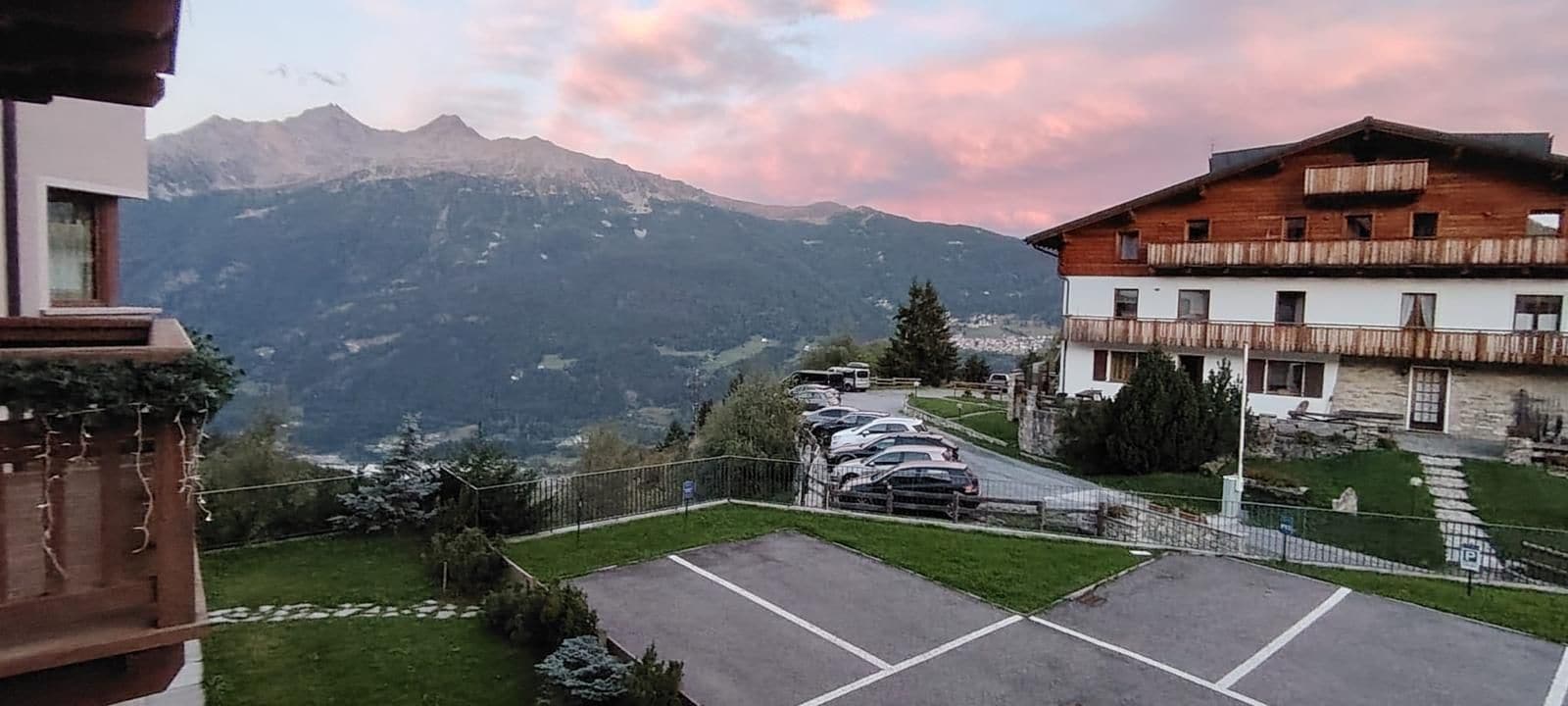 Paisagem montanhosa com área de estacionamento e edifícios com varandas.