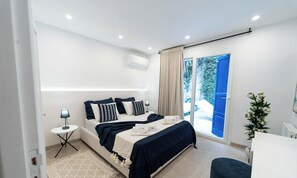 Quarto moderno com cama, mesa de cabeceira, luminária e vista para o exterior.