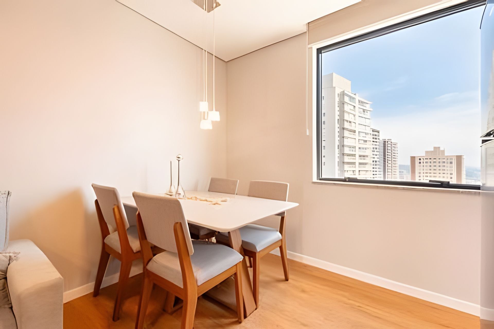 Uma sala de jantar moderna com uma janela grande, uma mesa e cadeiras.