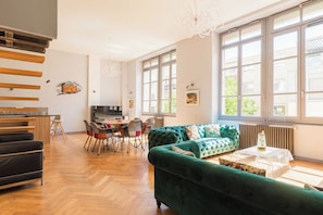 Uma sala de estar moderna com sofá, mesa de jantar, cadeiras e cozinha.