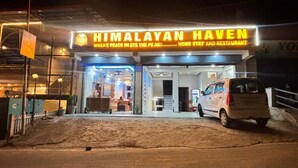 Um hotel chamado 'HIMALAYAN HAVEN' com um letreiro indicando que oferece acomodação e restaurante.