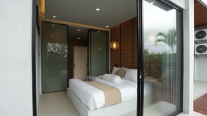 Quarto moderno com cama grande, portas de vidro deslizantes e vista para o exterior.