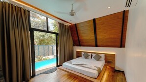 Quarto com piso de madeira, cama com travesseiros, ventilador de teto e vista para o exterior.
