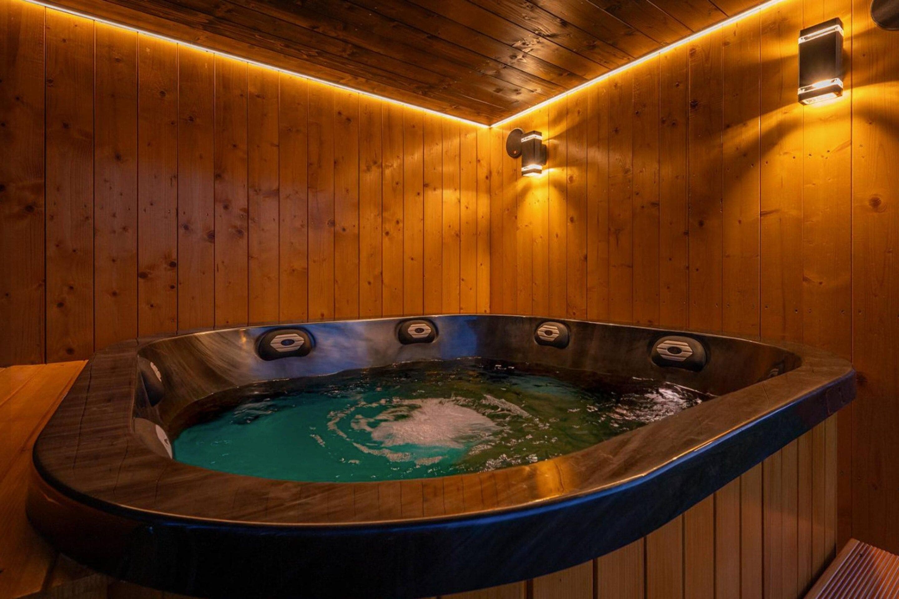 Uma cabana de madeira com uma banheira de hidromassagem.