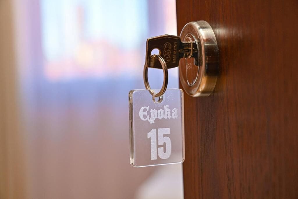 Uma chave em uma fechadura, com um porta-chaves rotulado 'Epoha 15'.