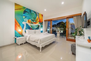 Quarto moderno com uma cama grande, uma mesa de cabeceira, uma escrivaninha e vista para o exterior.