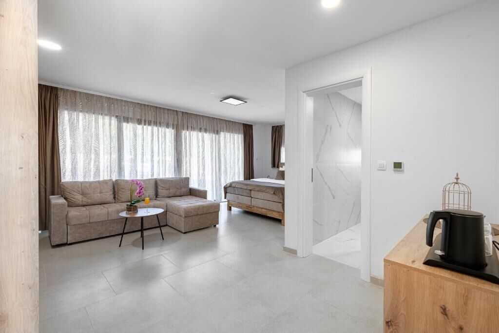 Uma sala de estar moderna com sofá, mesa pequena e cama.