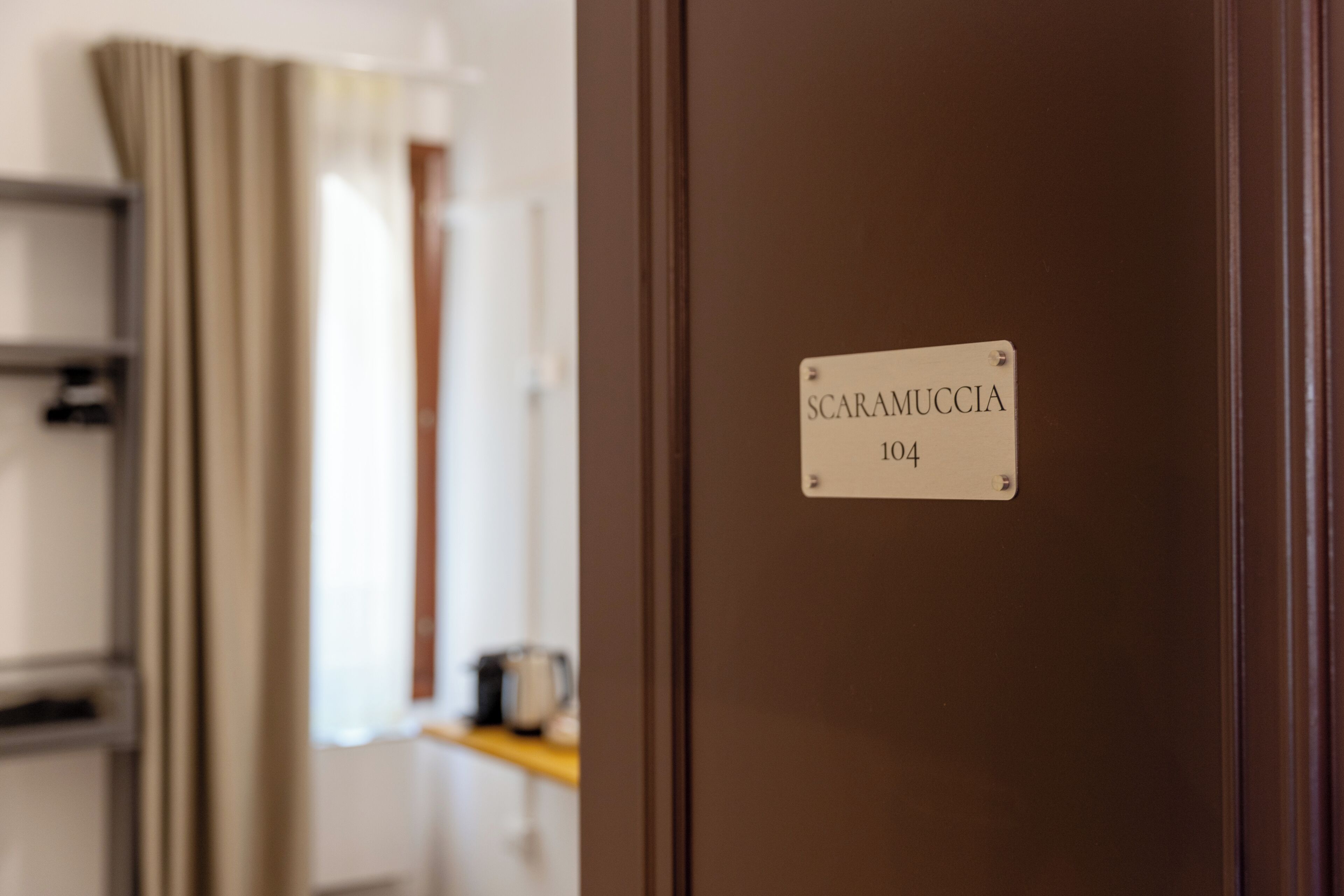 Uma porta com uma placa que diz 'SCARAMUCCIA 104'.