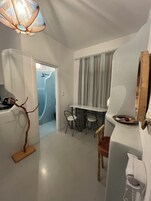 Decoração moderna com área de refeições, chuveiro e um espelho suspenso singular.