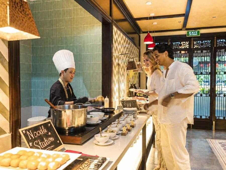 Buffet montado com um espaço para massas, um chef preparando comida e uma placa indicando o espaço para massas.