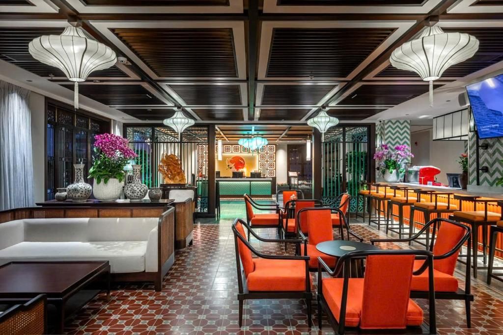 Um restaurante com área de bar, mesas e detalhes decorativos.