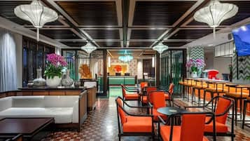 Um restaurante com área de bar, mesas e detalhes decorativos.