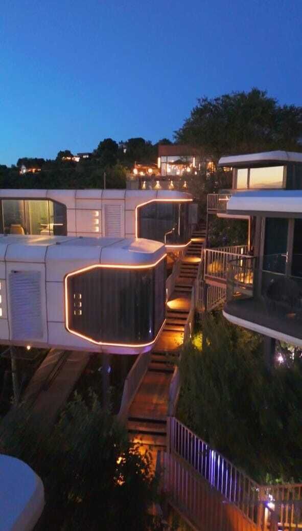 Um edifício residencial moderno, com vários níveis, varandas interligadas e escadarias.