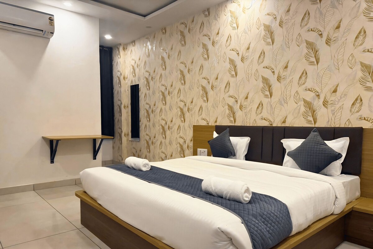 Cama bem arrumada com cabeceira, mesa de cabeceira e ar-condicionado fixado na parede.